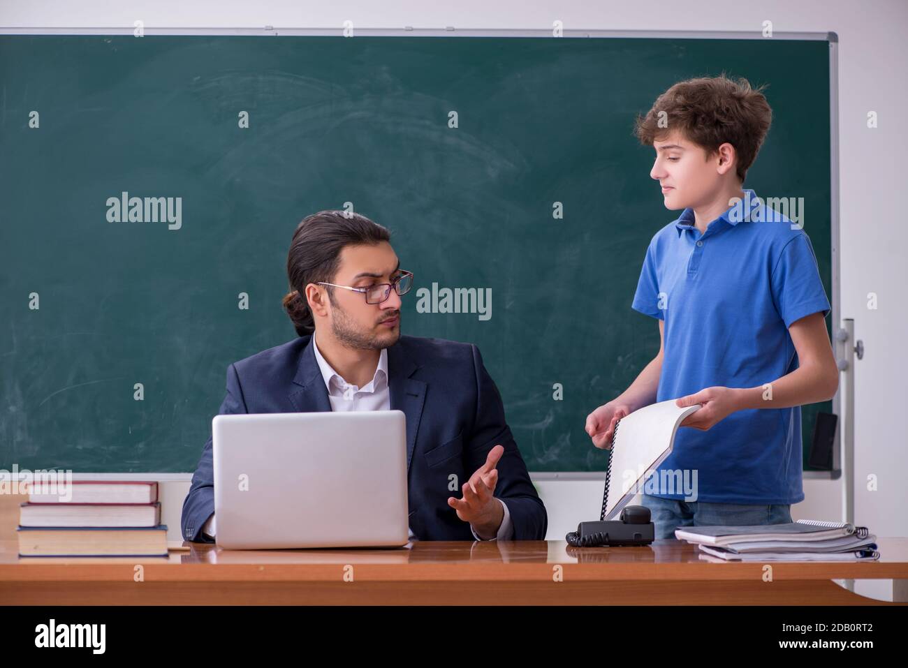 Male teacher and schoolboy in the classroom Stock Photo - Alamy