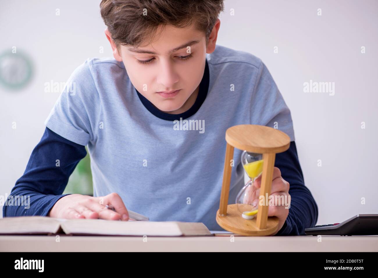 Boy preparing for exams in time management concept Stock Photo - Alamy