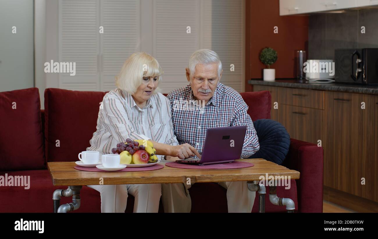Happy smiling senior couple with laptop pc computer at home. Cheerful ...
