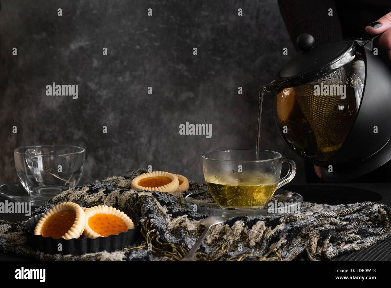 Relaxing tea time concept. Dark mood view of herbal tea and cookies ...