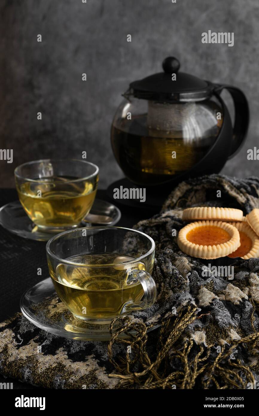 Relaxing tea time concept. Dark mood view of herbal tea and cookies ...