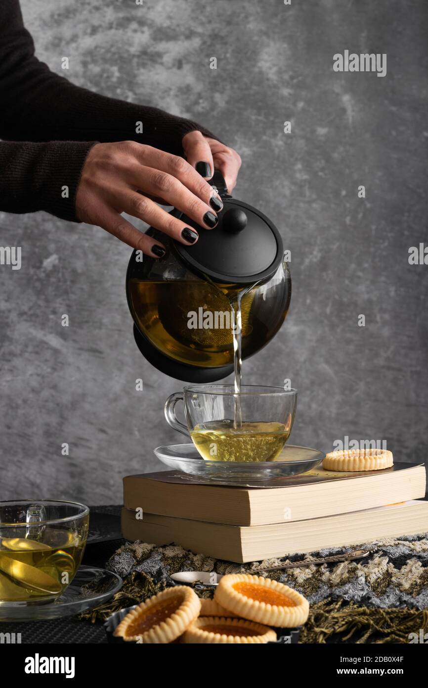 Woman hands pouring tea from a teapot Stock Photo - Alamy