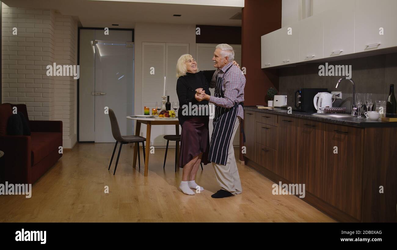 Happy senior couple in love dancing. Romantic evening supper with wine ...