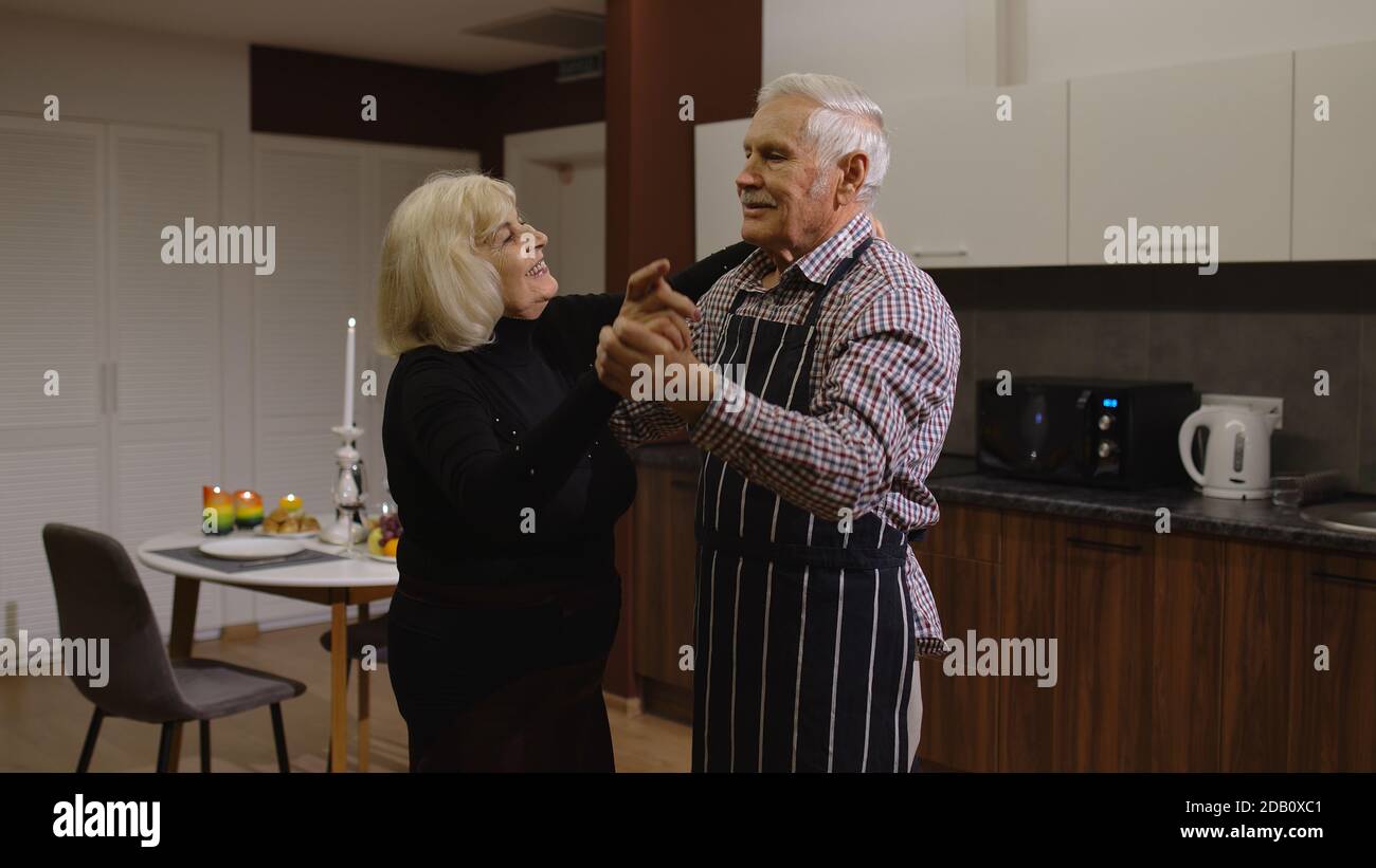 Happy senior couple in love dancing. Romantic evening supper with wine ...