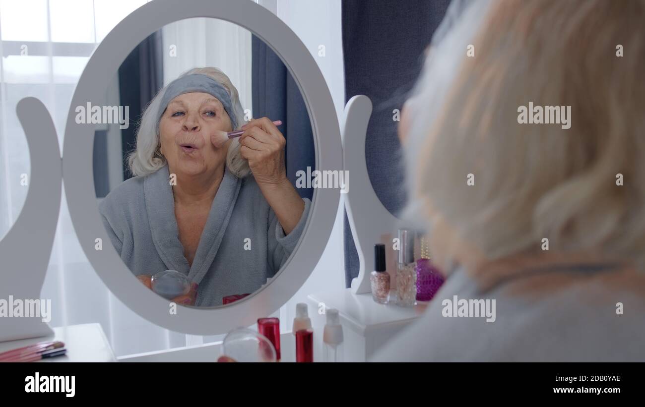 Old senior woman grandmother taking care of skin, applying anti-wrinkle ...