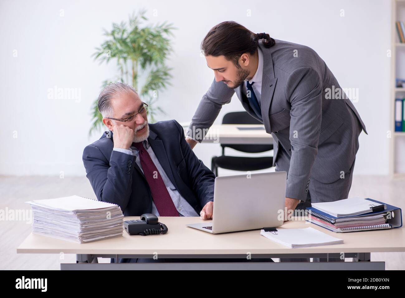 Old boss and his assistant working in the office Stock Photo - Alamy