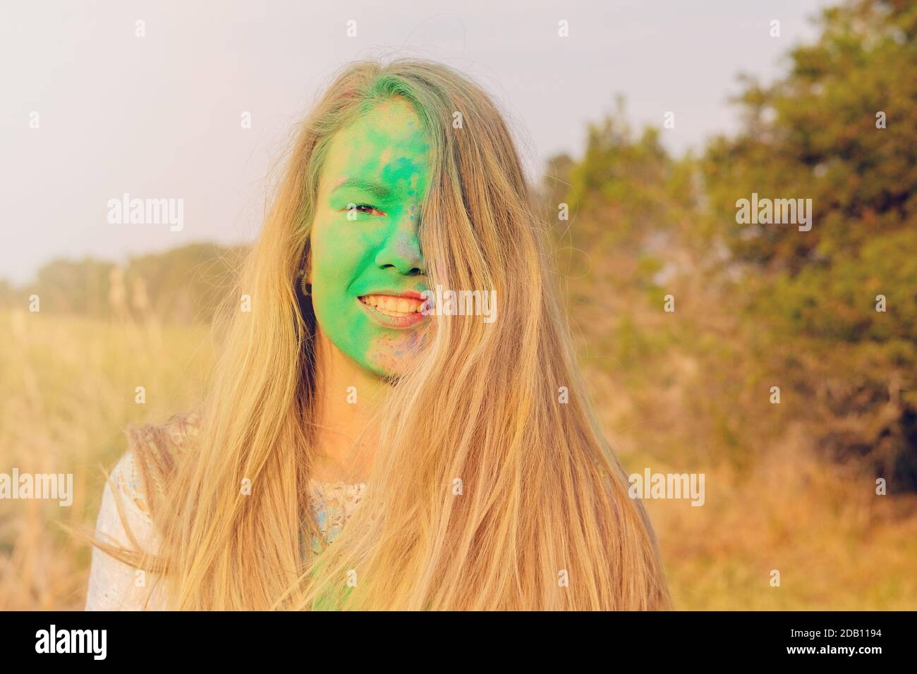 Blond lady with colorful dust on face Stock Photo - Alamy