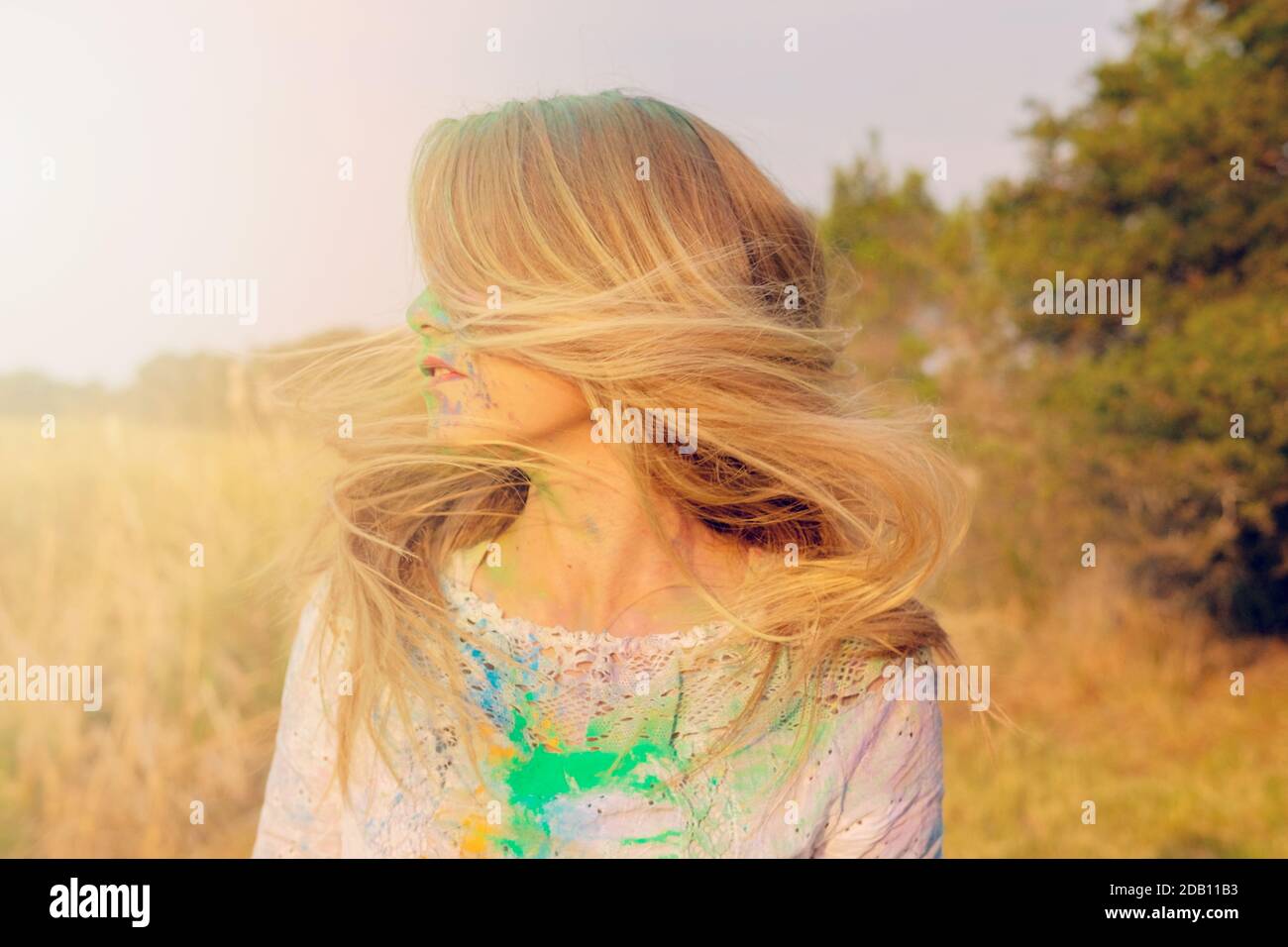 Blond lady with colorful dust on face Stock Photo - Alamy