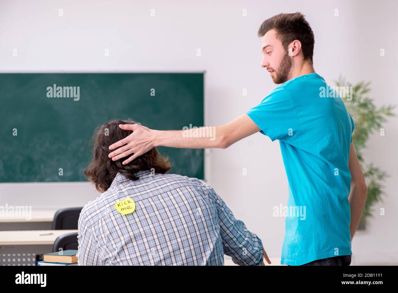 Male pupils in bullying concept in the classroom Stock Photo - Alamy
