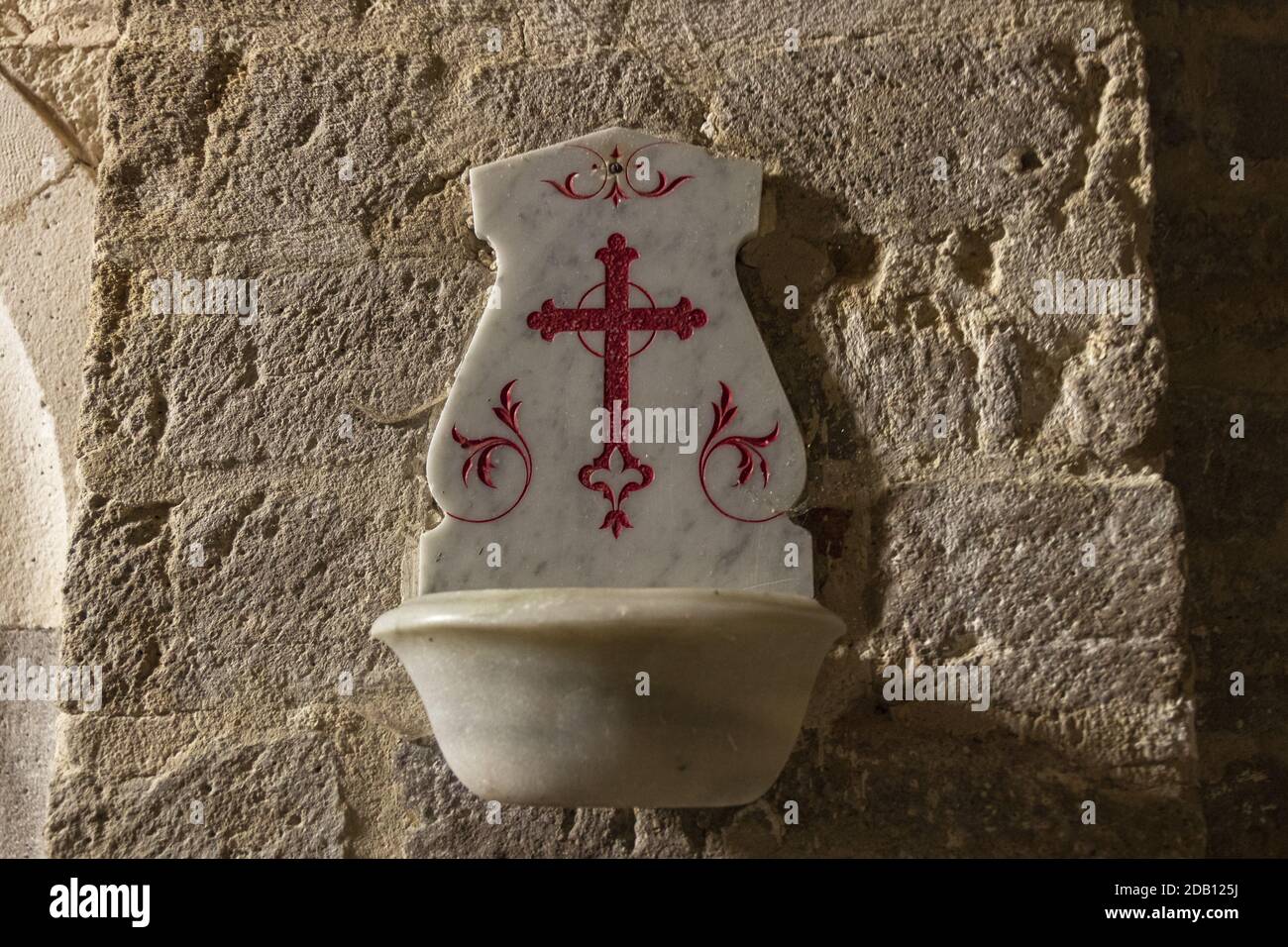 An old marble container for baptism water hanging on a church wall ...