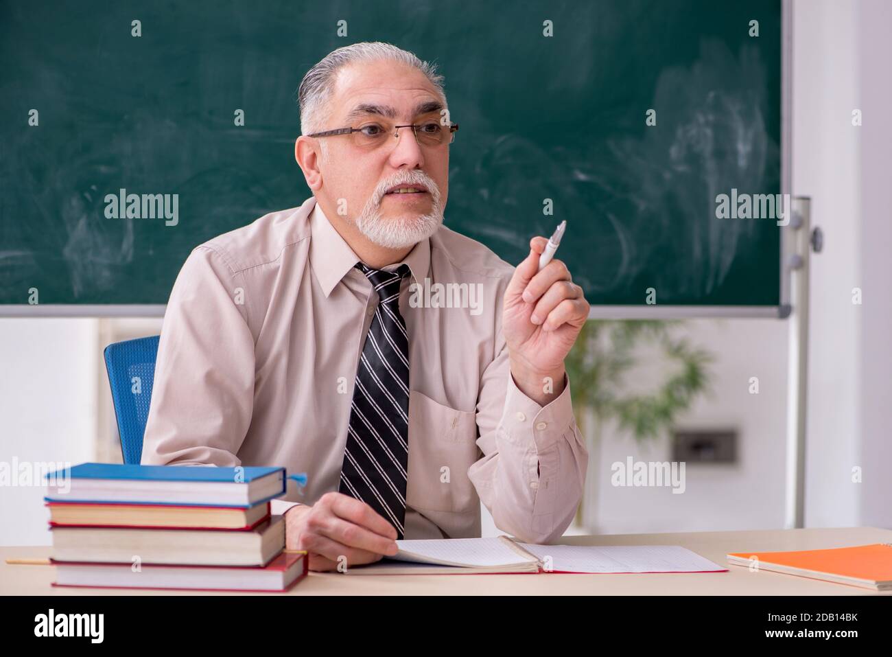 Old experienced teacher in the classroom Stock Photo - Alamy