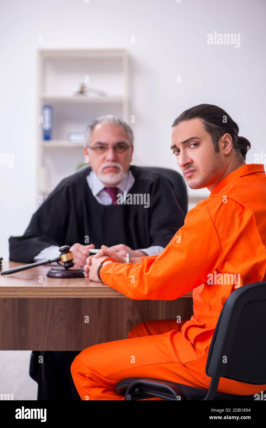 Old judge meeting with young captive in courthouse Stock Photo - Alamy