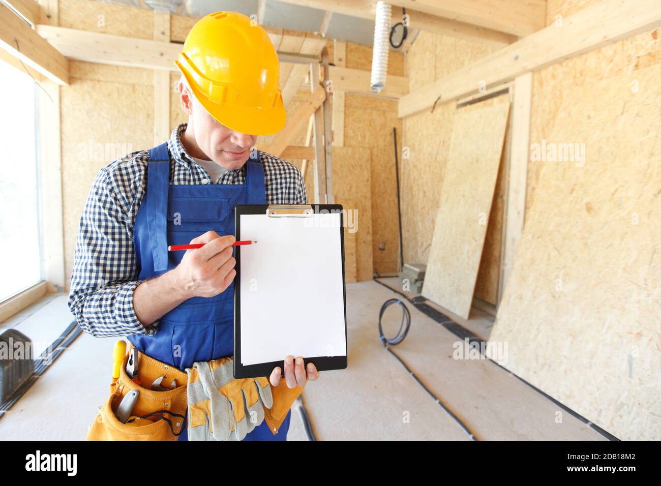 Worker showing document at construction site area, blank copy space for ...