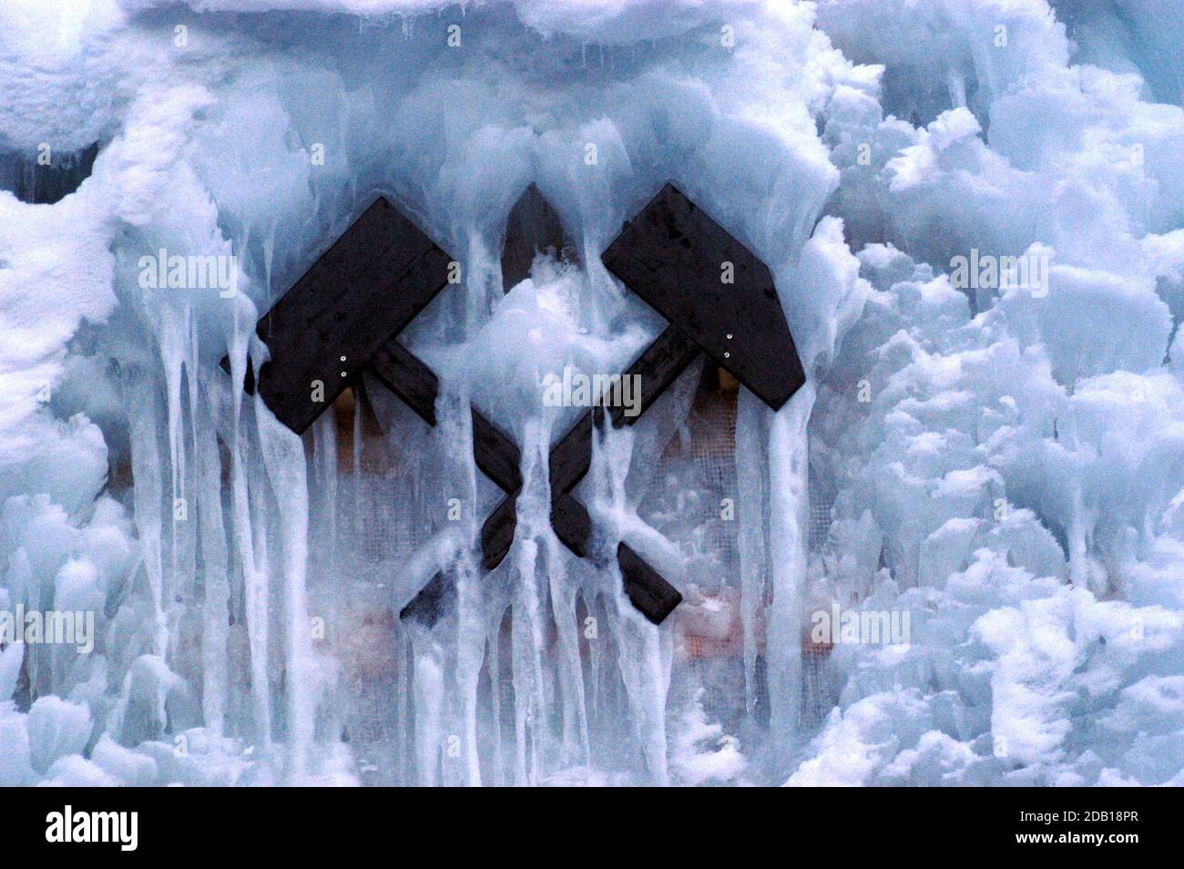 crossed hammer and pickaxe, mining symbol covered in snow and ice Stock ...