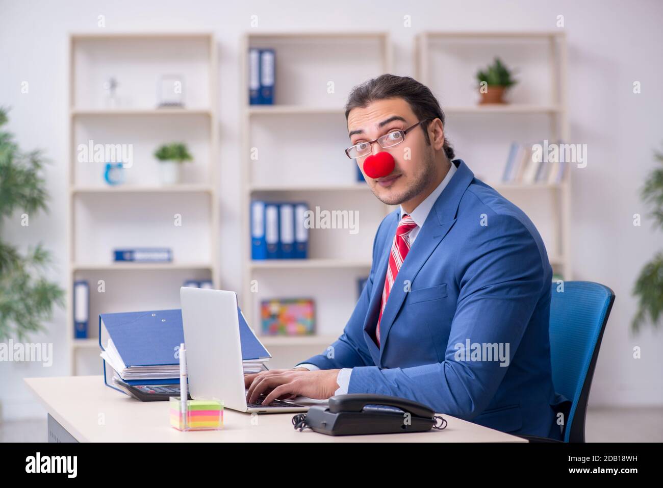Funny employee clown working in the office room Stock Photo - Alamy