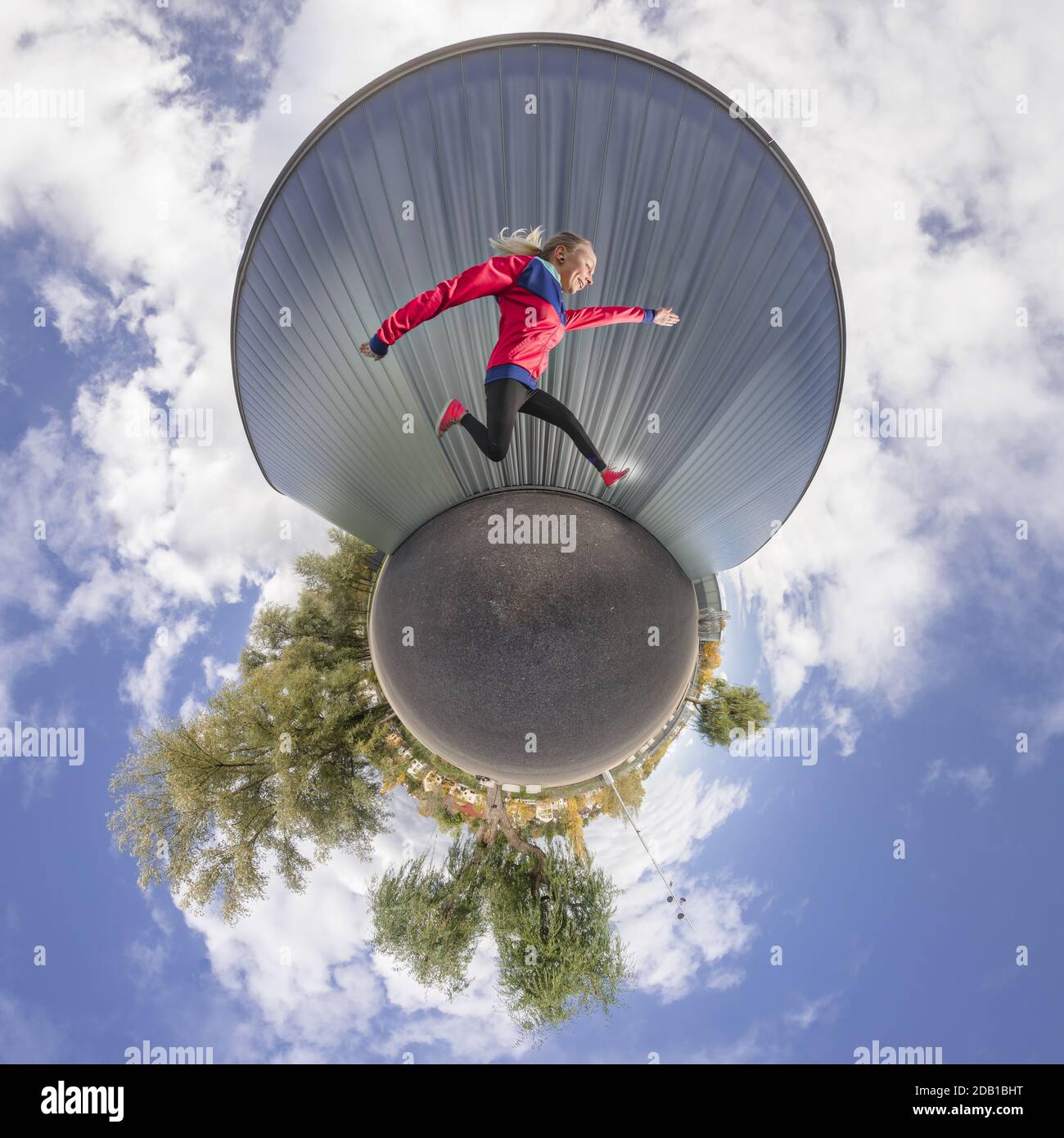 young women in a acrobatic jump in front of a building wall, shot as ...