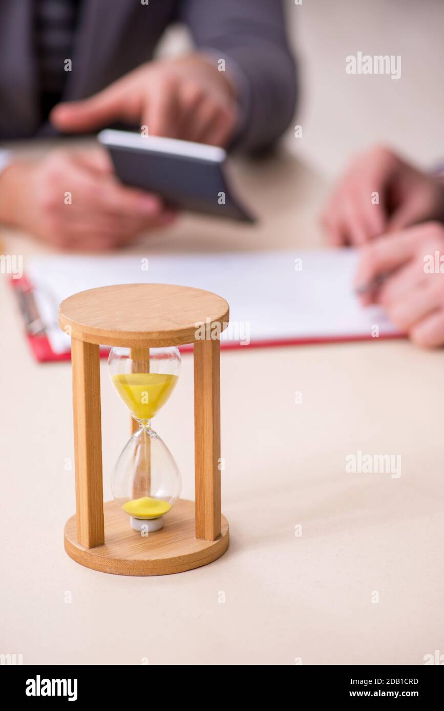 Two businessmen in the time management concept Stock Photo - Alamy