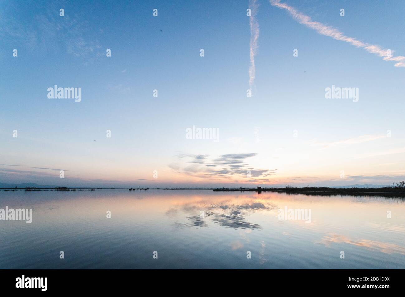 Sunset at albufera lake with reflection of the sky Stock Photo - Alamy