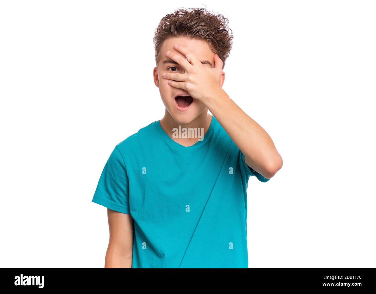 Handsome teen boy with sad expression covering face with hands while ...