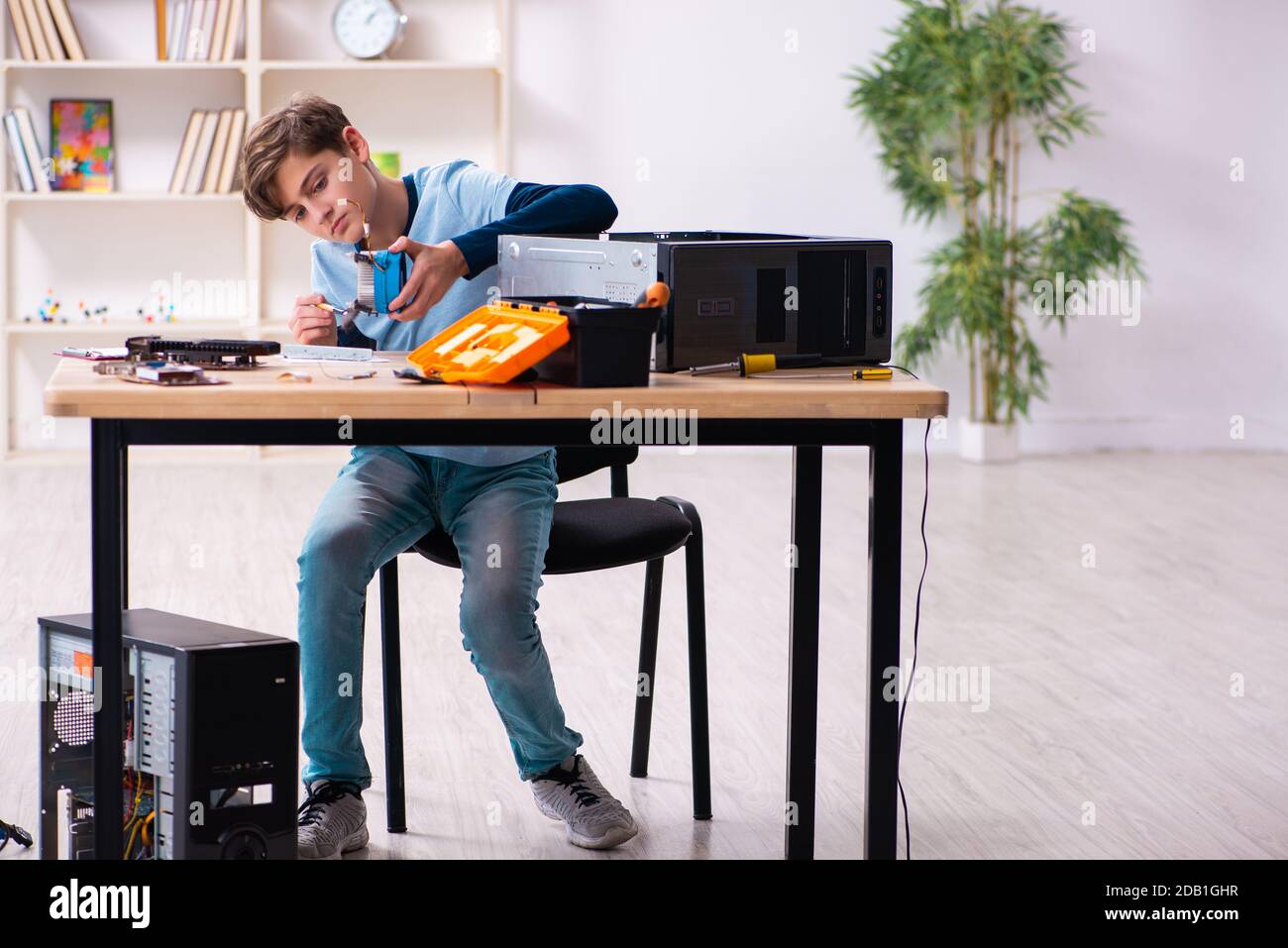 Teenager reparing computers at workshop Stock Photo - Alamy