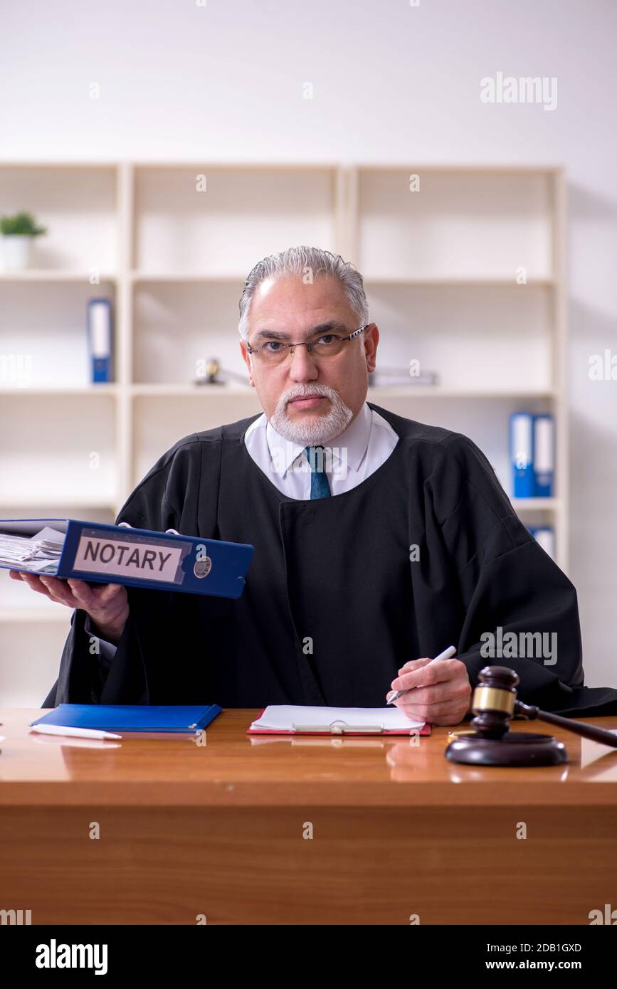 Old male judge working in the courthouse Stock Photo - Alamy