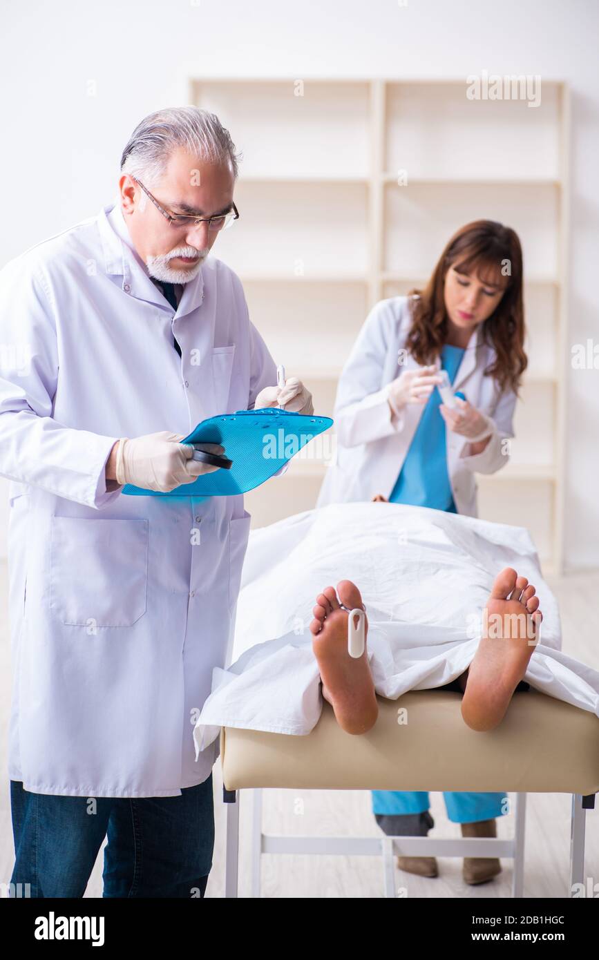 Police coroner examining dead body corpse in the morgue Stock Photo - Alamy