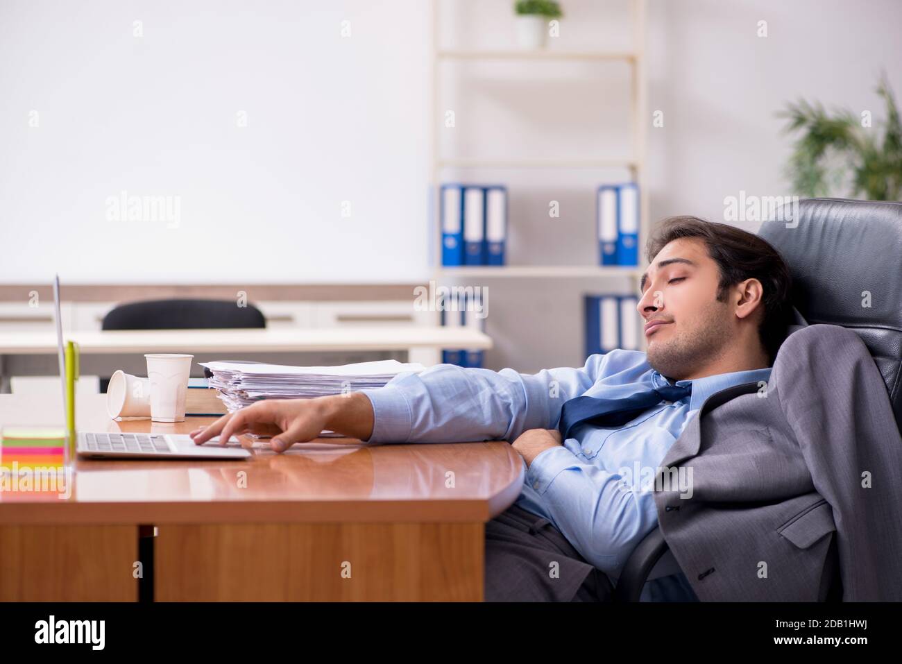 Young employee sleeping in the office Stock Photo - Alamy