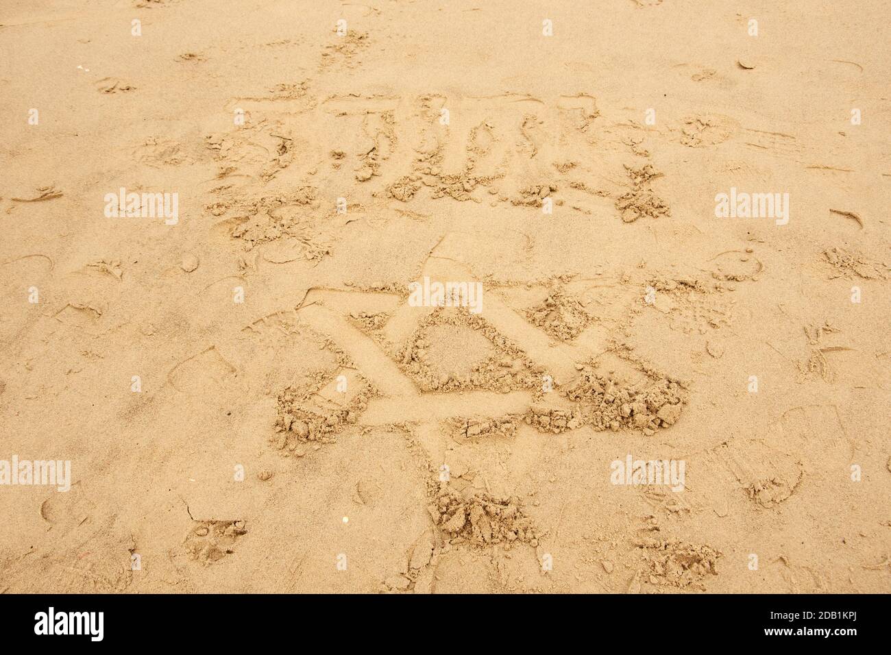 Star of David drawn on the sand beach in Tel Aviv, Israel and over it ...