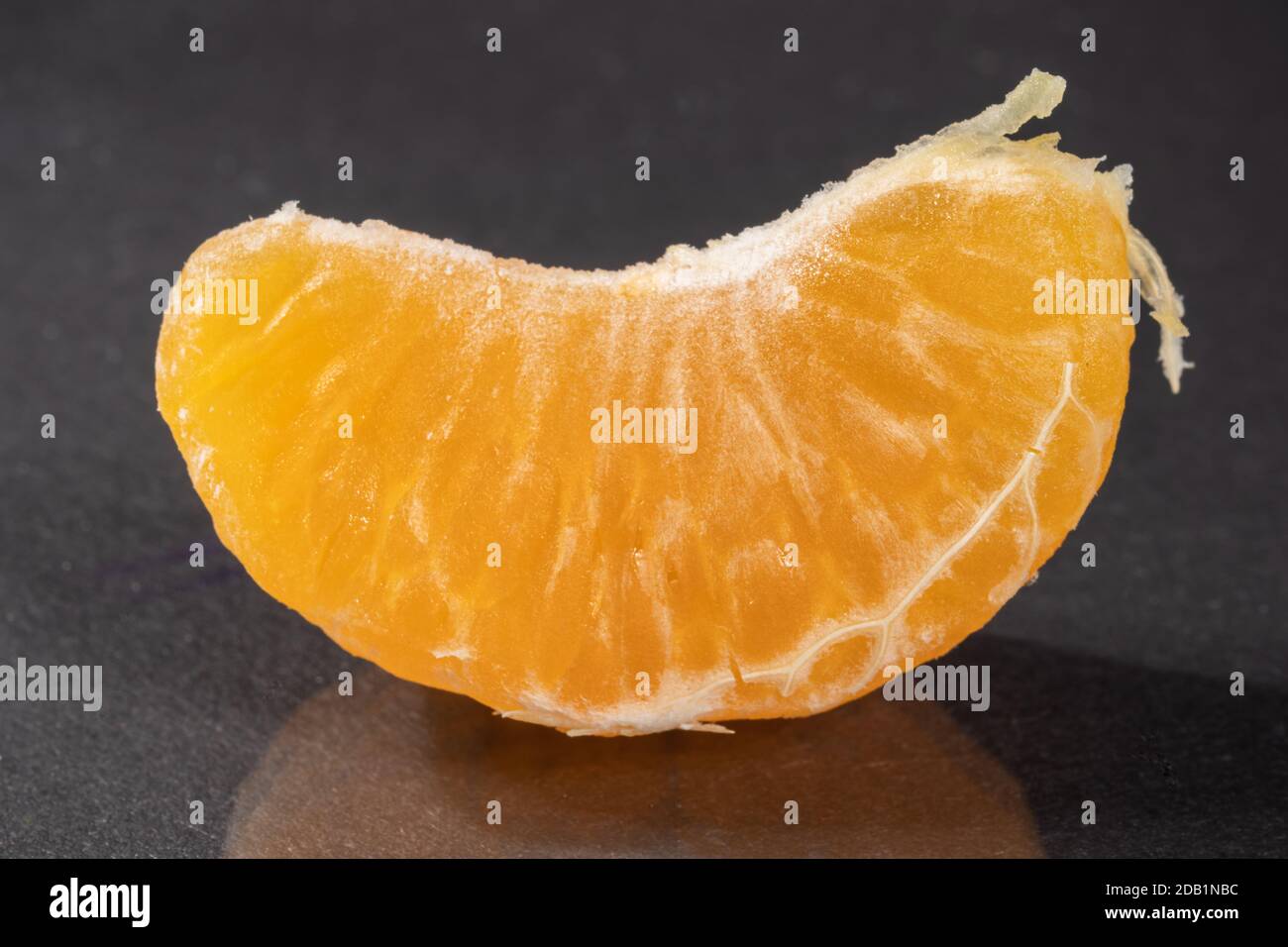 One piece of mandarin close-up. Black background. Tropical fruit Stock ...