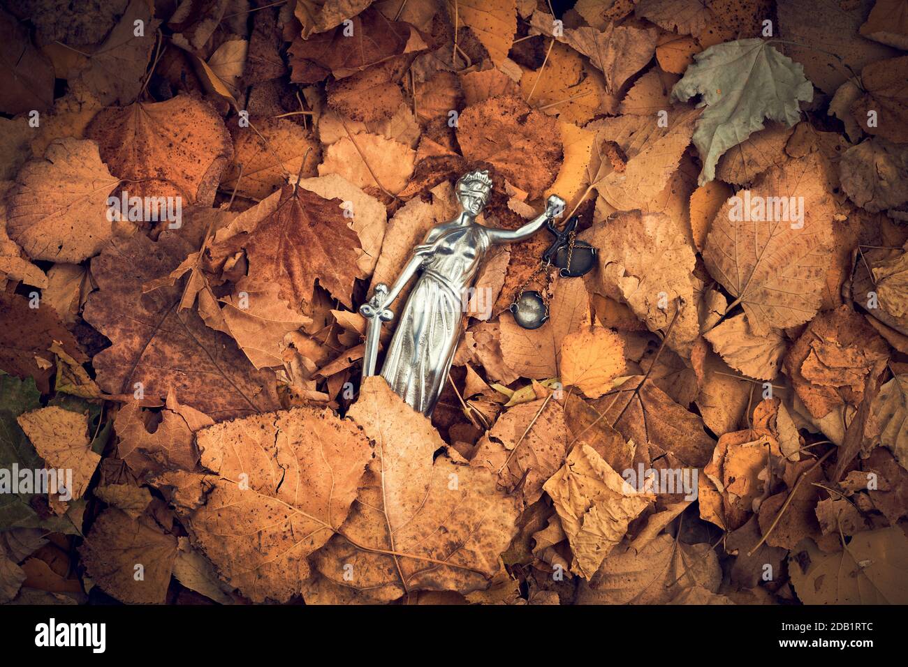 Lady Justice statue in pile of dry autumn leaves, flat lay top view ...