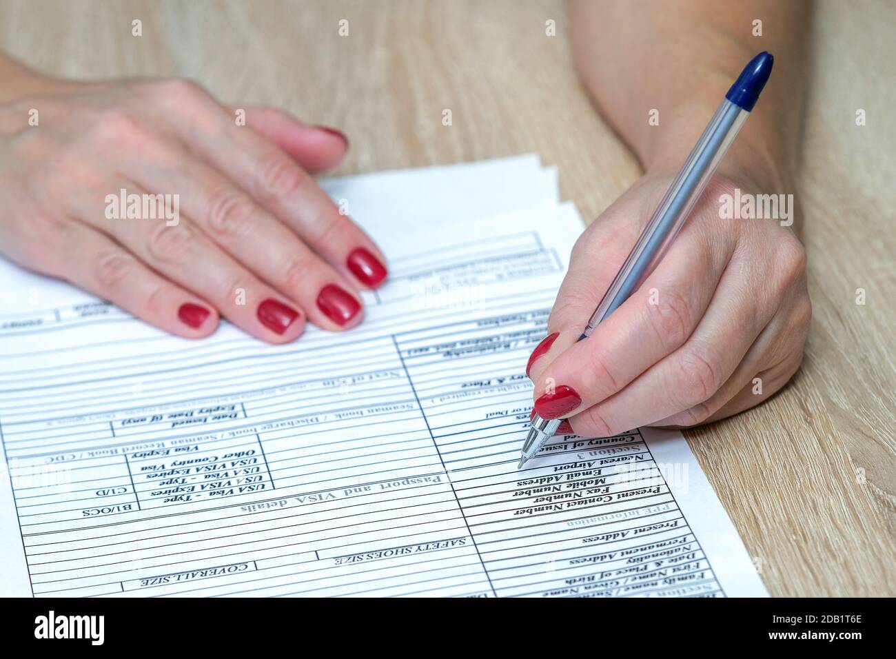Application form. Hand holding the pen ready to fill out a list of ...