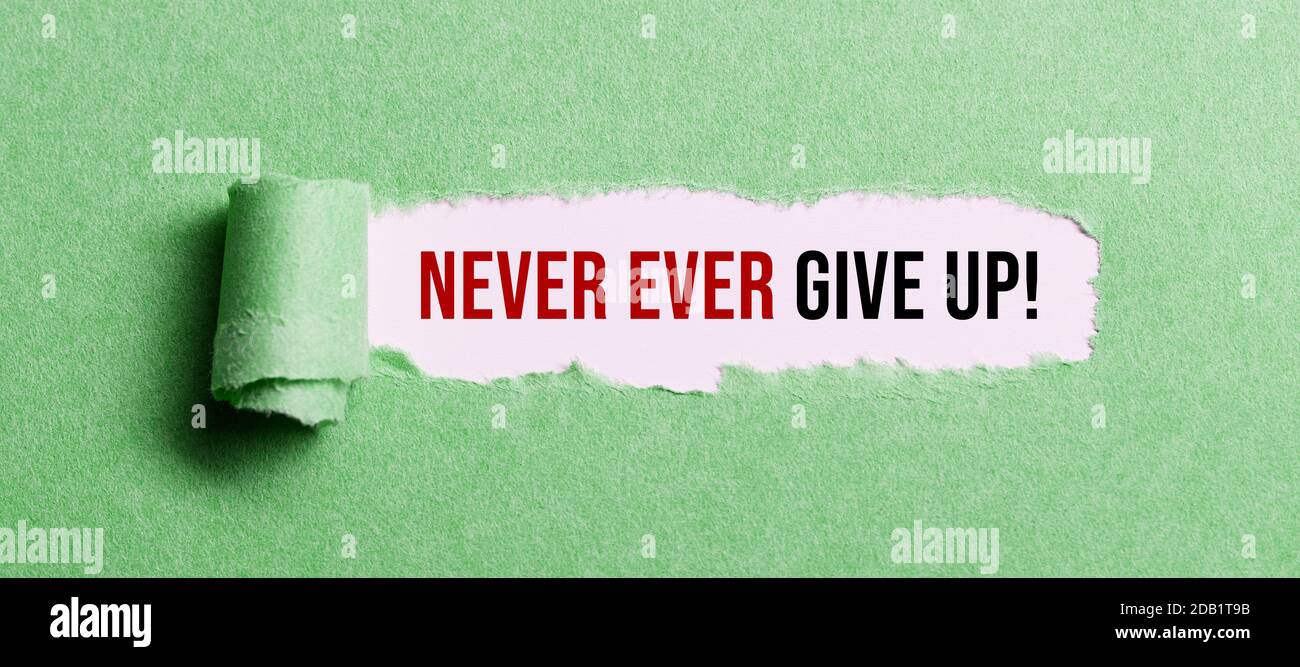 torn paper revealing the message NEVER EVER GIVE UP! Stock Photo - Alamy