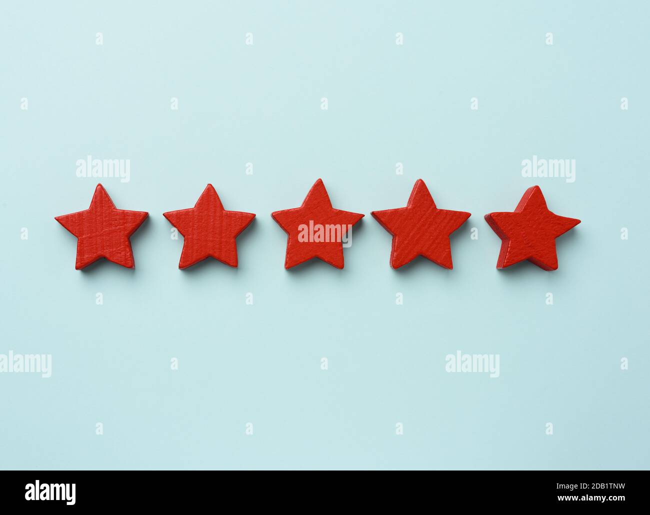 five red wooden stars on a blue background, high score, rating Stock ...