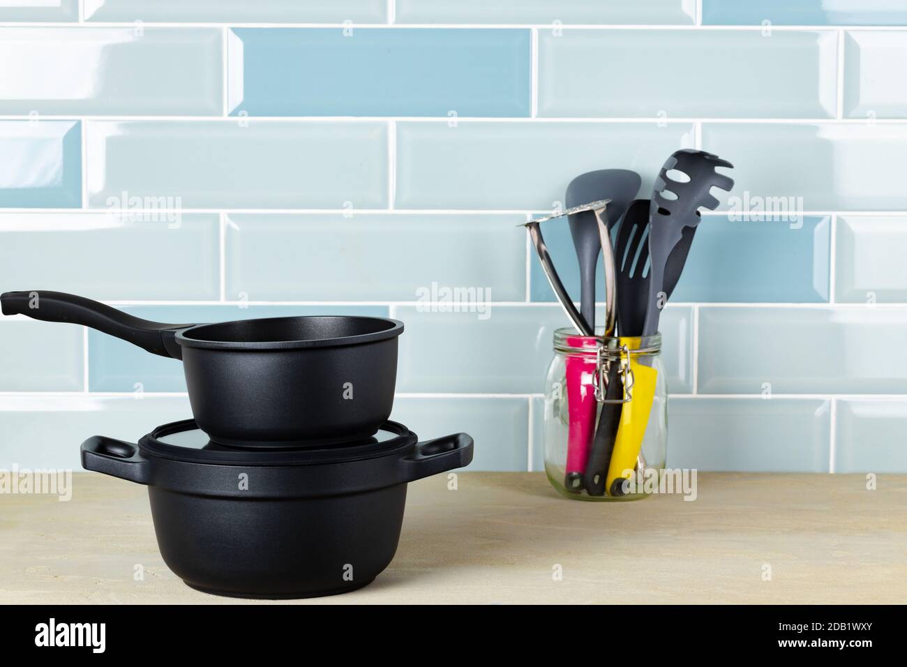 Set of black cookware on kitchen counter Stock Photo - Alamy