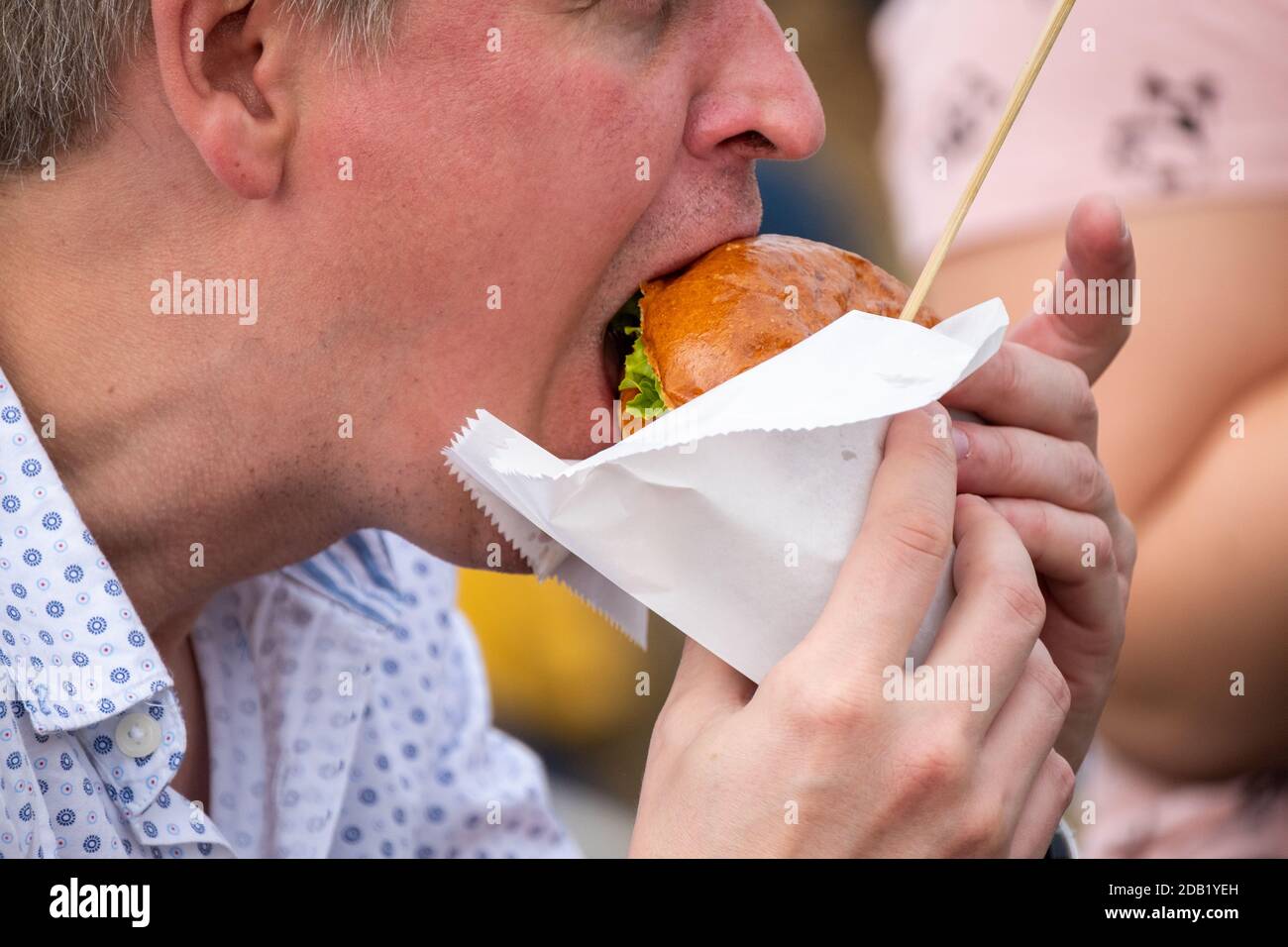 Hungry man eating yummy burger Stock Photo - Alamy