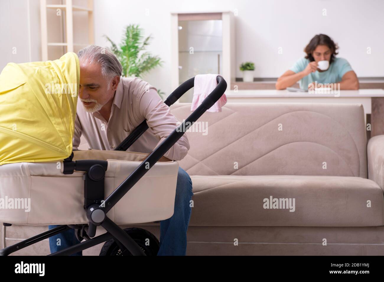 Old grandfather looking after newborn at home Stock Photo - Alamy
