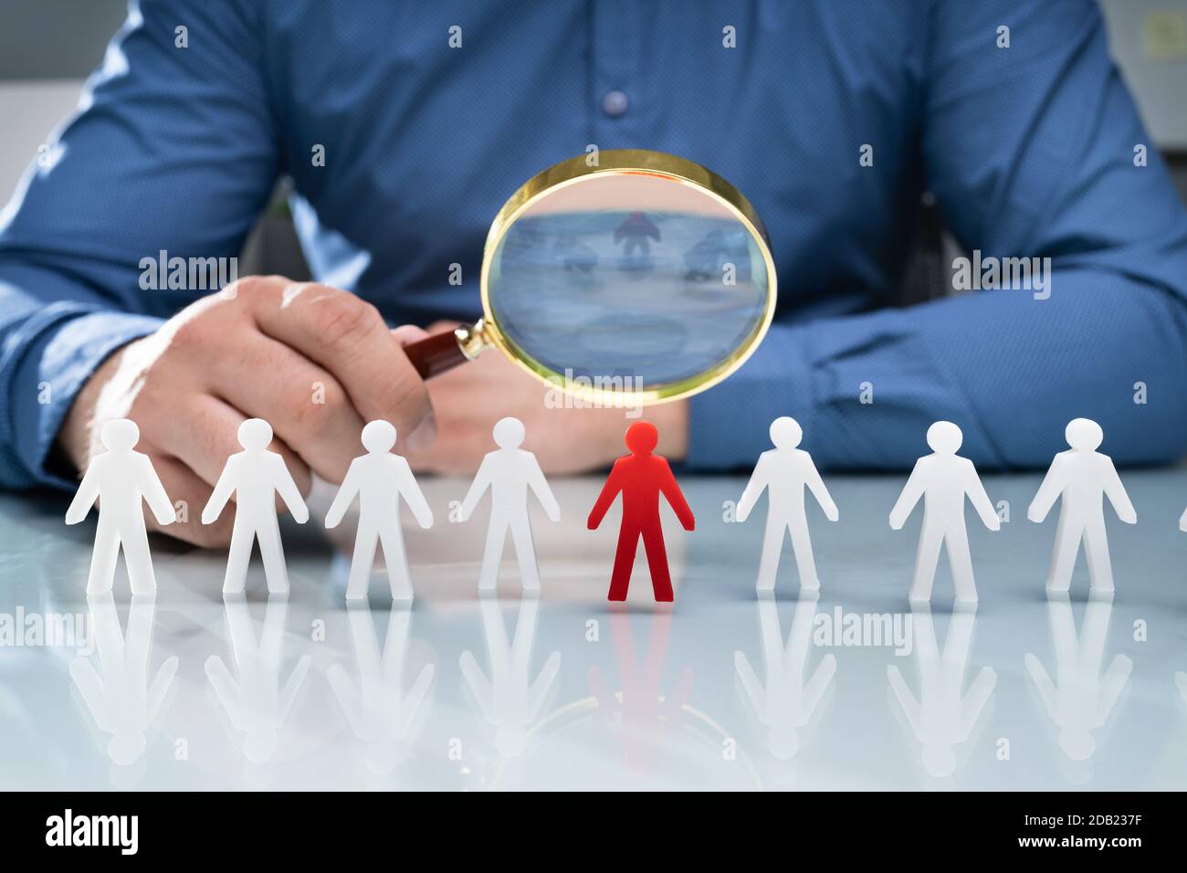 Close-up Of A Businessperson's Hand Holding Magnifying Glass Over Red ...