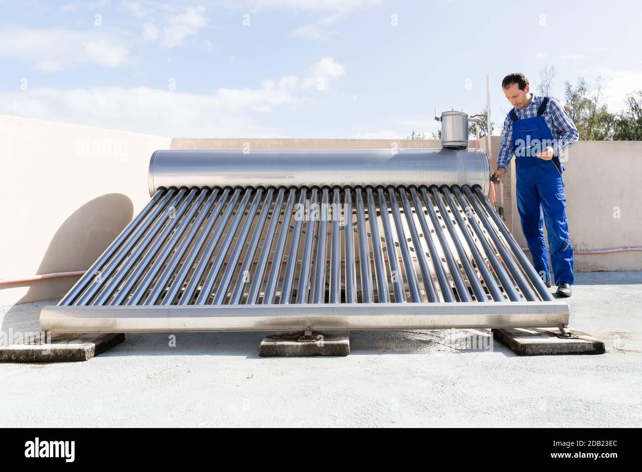 Male Plumber Doing Solar Energy Boiler Inspection Stock Photo - Alamy