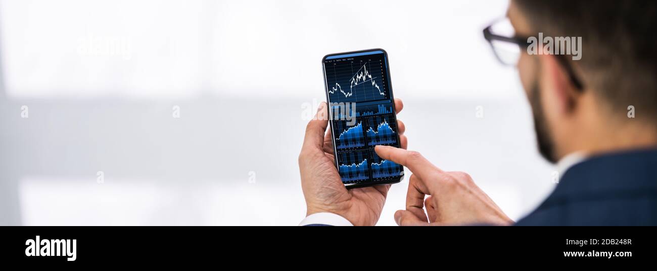 Close-up Of A Stock Market Broker Using Mobile Phone With Graph On ...