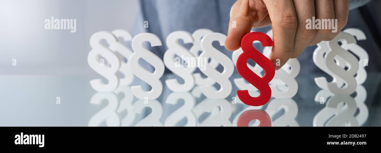 Close-up Of Businessman's Hand Holding Red Paragraph Sign With White ...