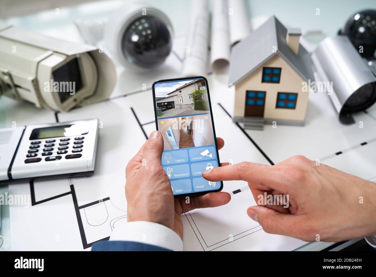 Person Hand Using Home Security System On Mobilephone With On Blueprint ...