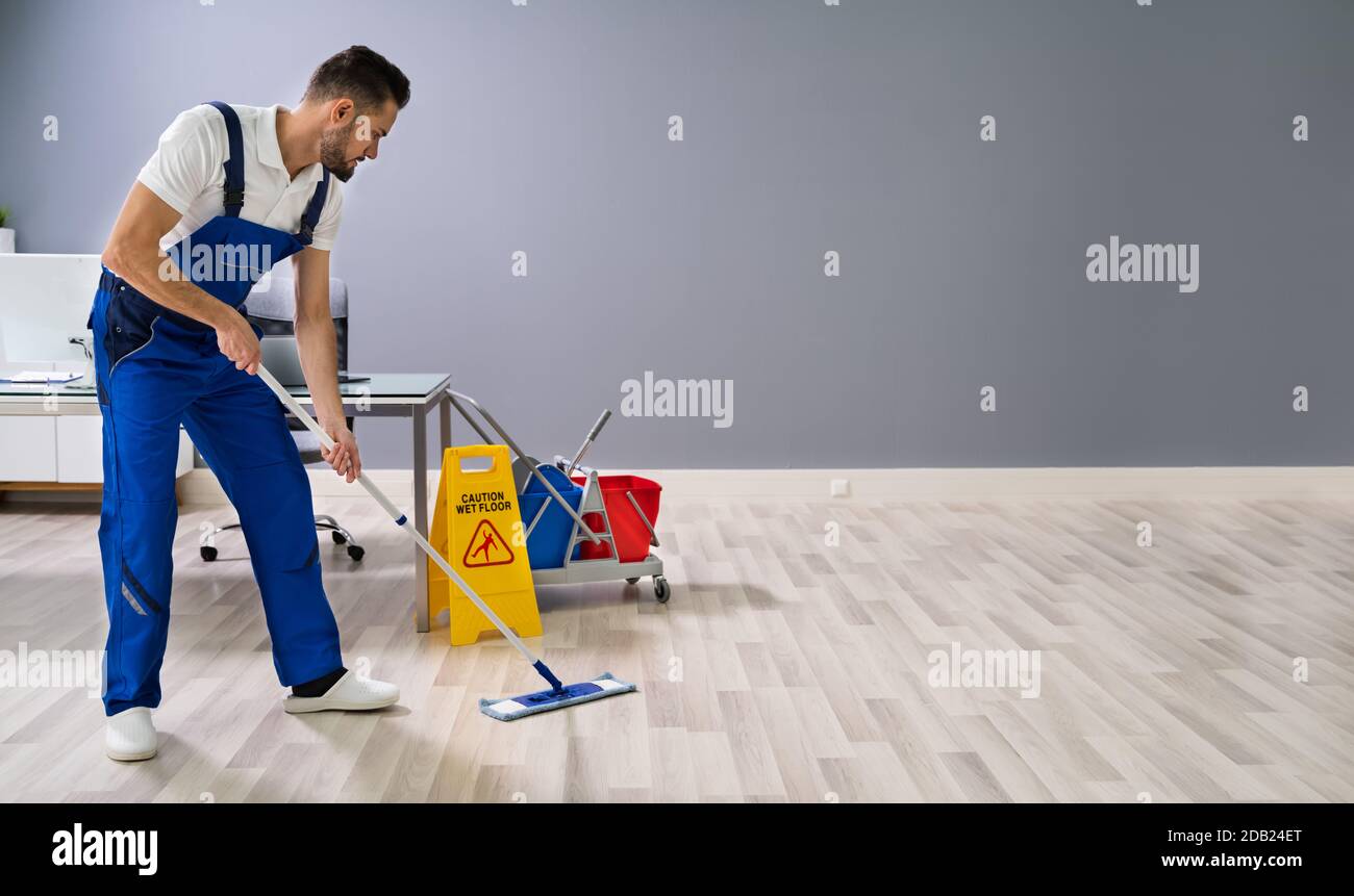 Man With Mop And Wet Floor Sign Stock Photo - Alamy