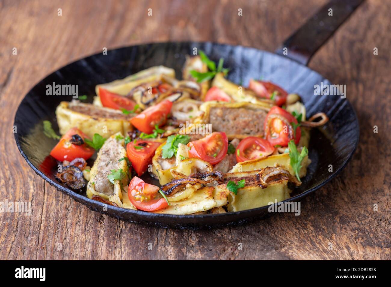 swabian maultasche with onions in an iron pan Stock Photo - Alamy
