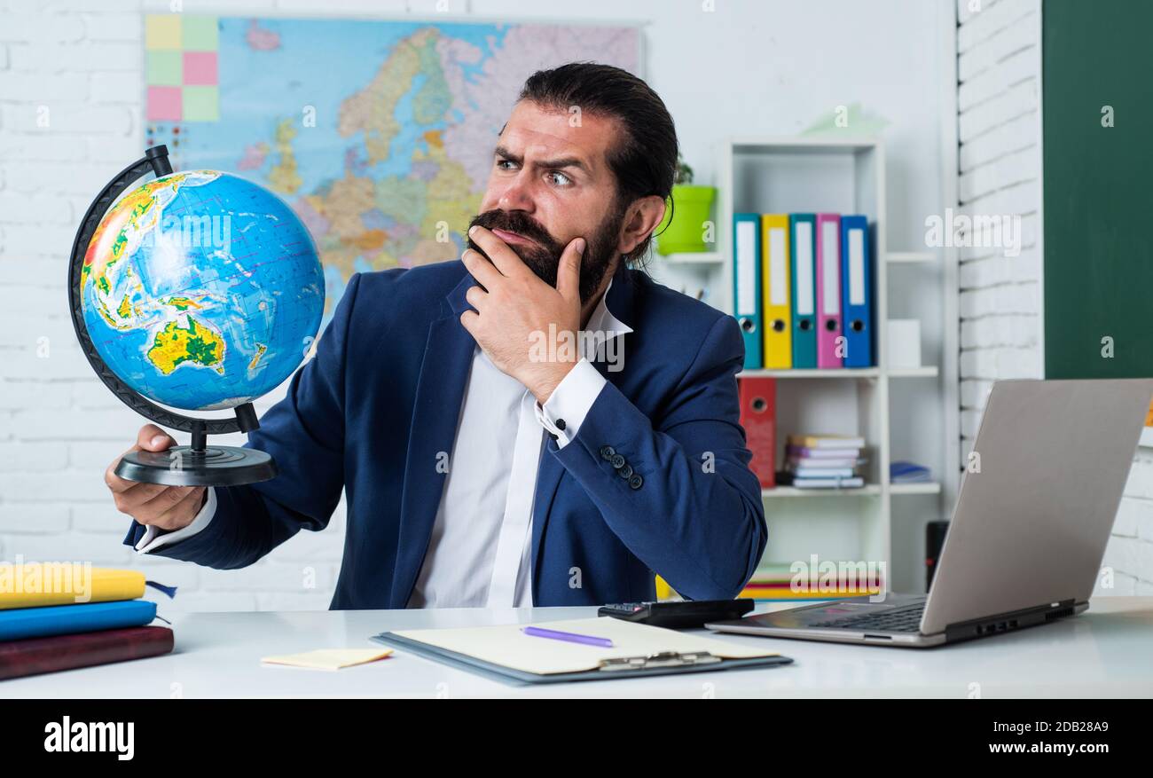 bearded man geographer work in classroom with map. prepare for exam ...