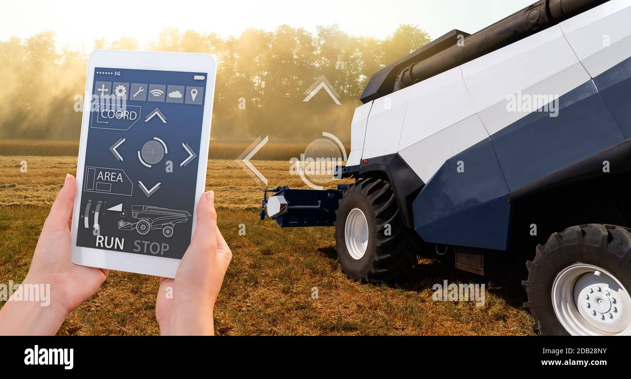 Farmer uses a digital tablet to control autonomous harvester. Smart ...