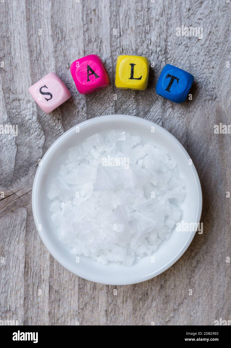Salt in bowl with letter cube on wooden background Stock Photo - Alamy
