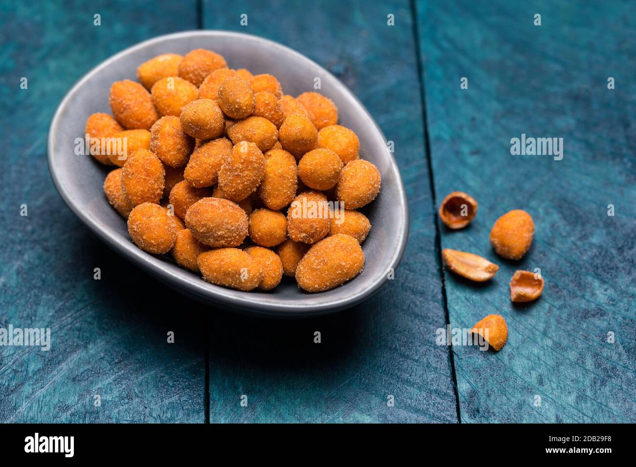 Peanuts in batter on petrol wood in bowl Stock Photo - Alamy