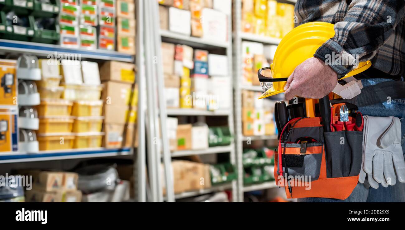 Electrician in the electrical component store holds the helmet and ...