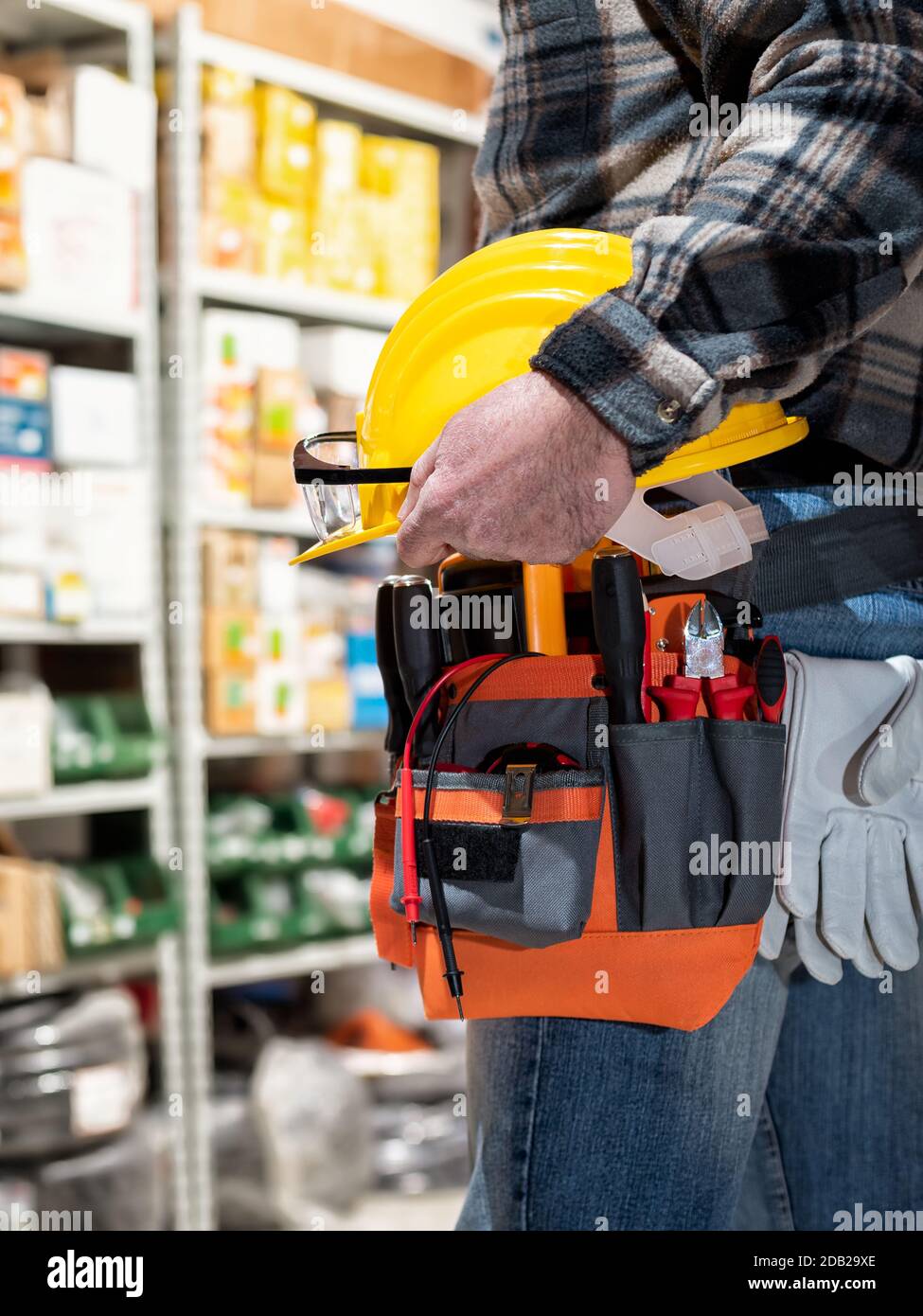 Electrician in the electrical component store holds the helmet and ...