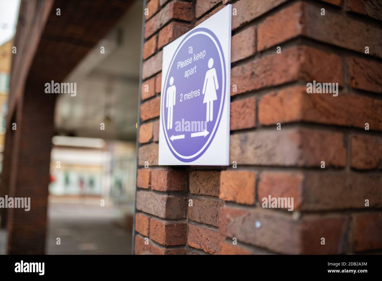 Sign on brick wall requesting people to keep a safe distance Stock ...